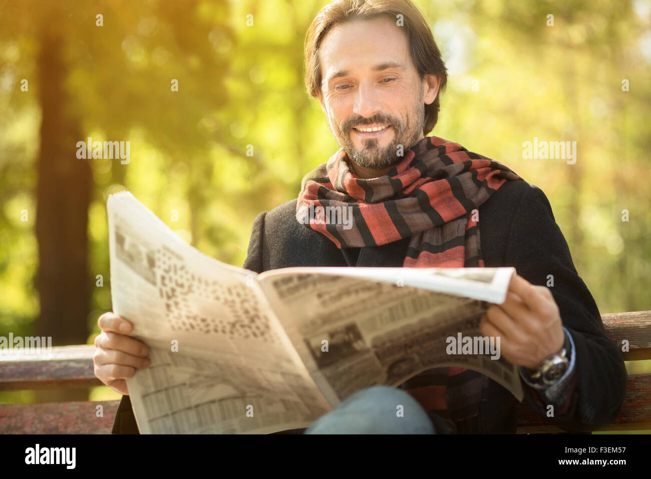 Man reading newpaper in the park Stock Photo - Alamy