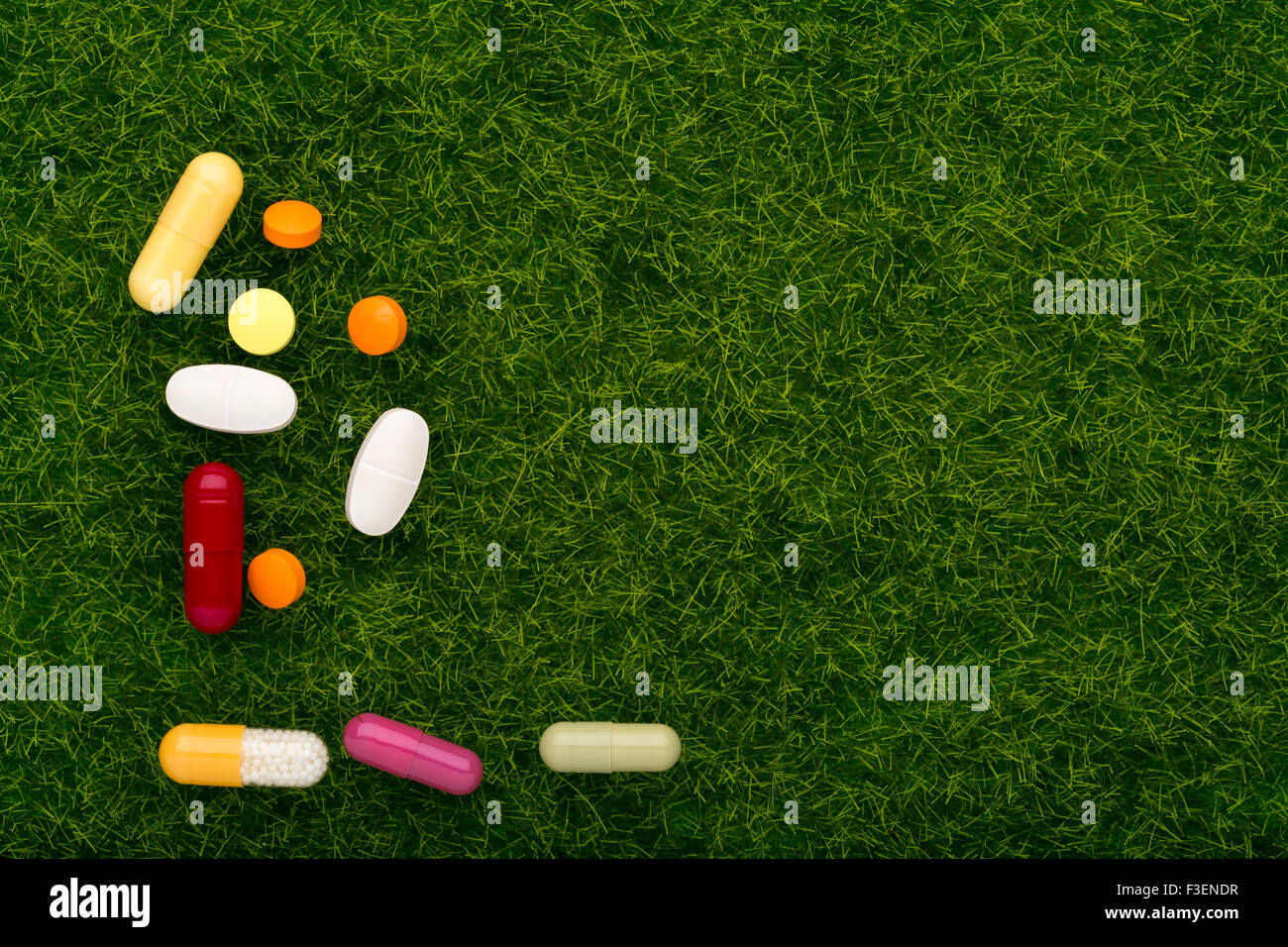 Colorful pills on an green grass background.Top view Stock Photo - Alamy