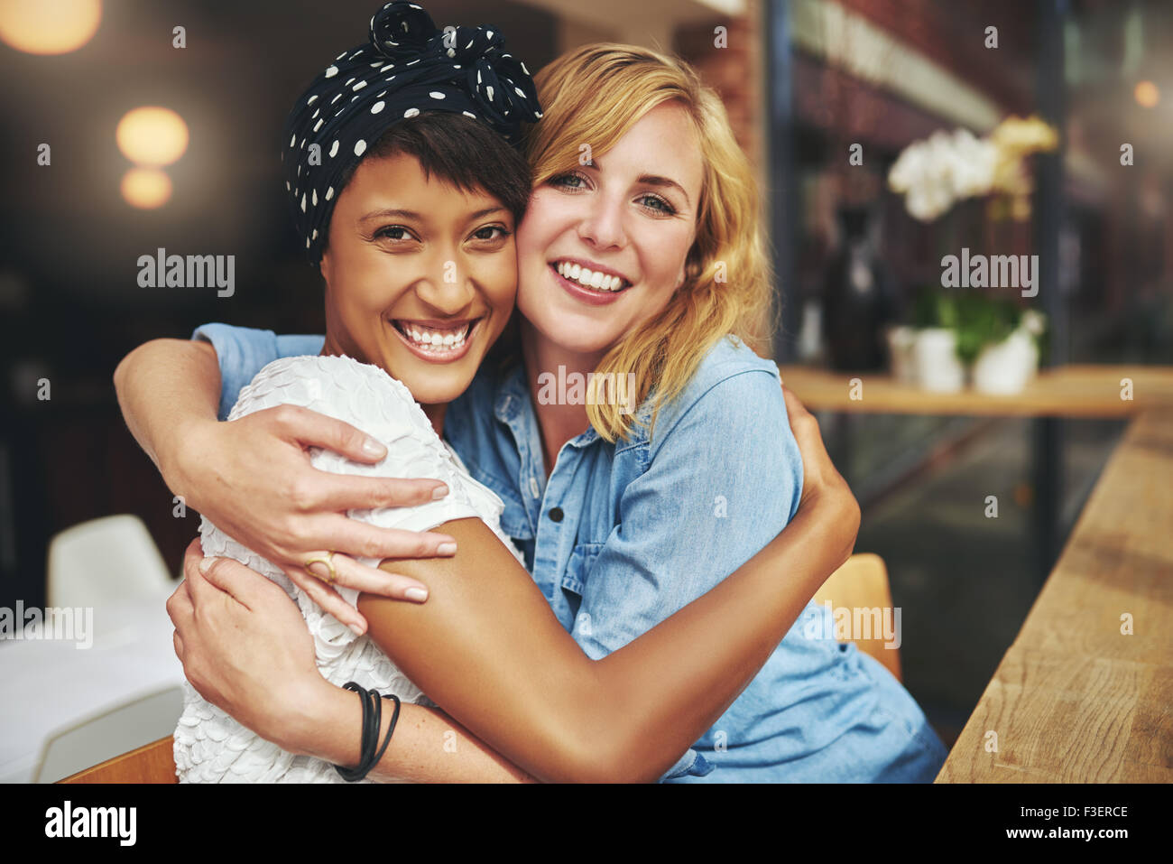 Two happy affectionate young woman hugging each other in a close ...