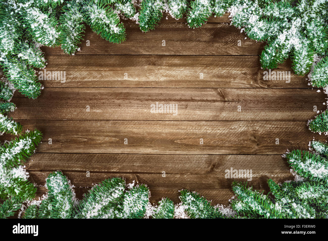 Wood planks background framed with snow covered fir twigs, a studio ...