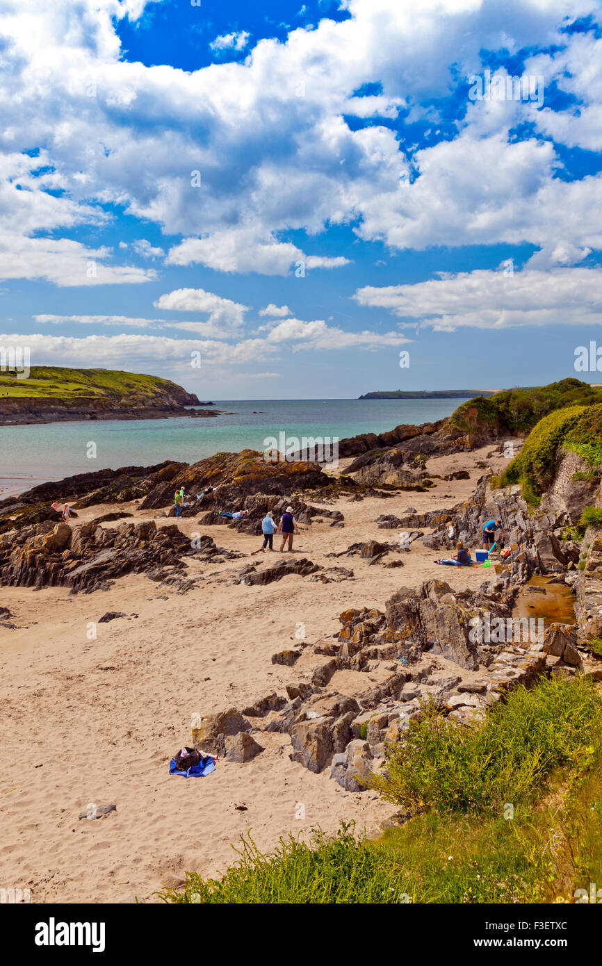 Visitors enjoying the sunshine on a beach in West Angle Bay in the ...