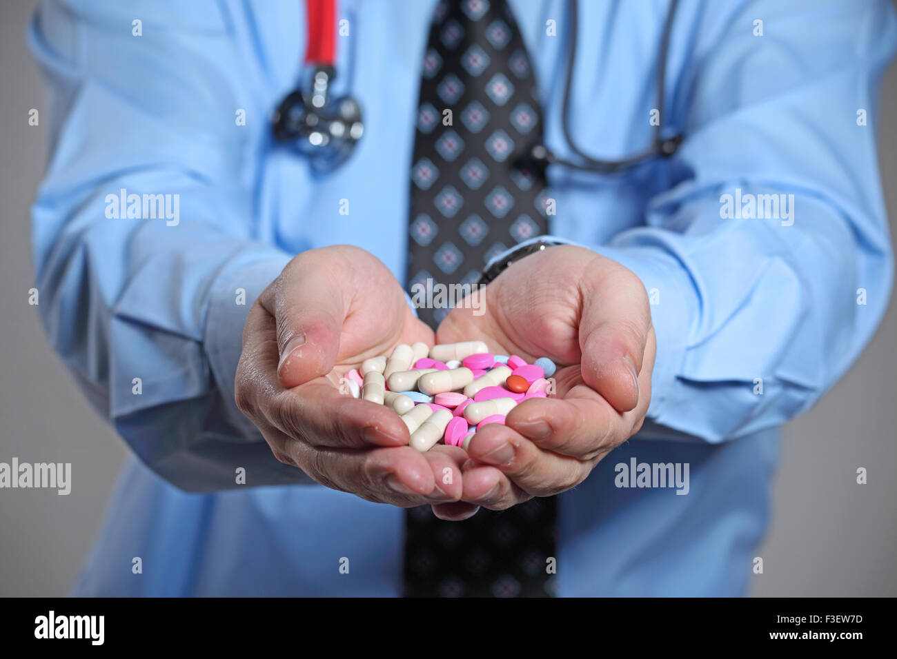 Closeup of a doctor's hand holding a pile of different types of ...