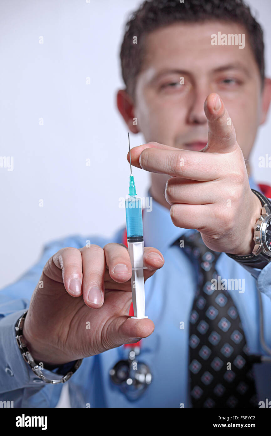 Doctor preparing a syringe with vaccine by tapping it to remove the air ...
