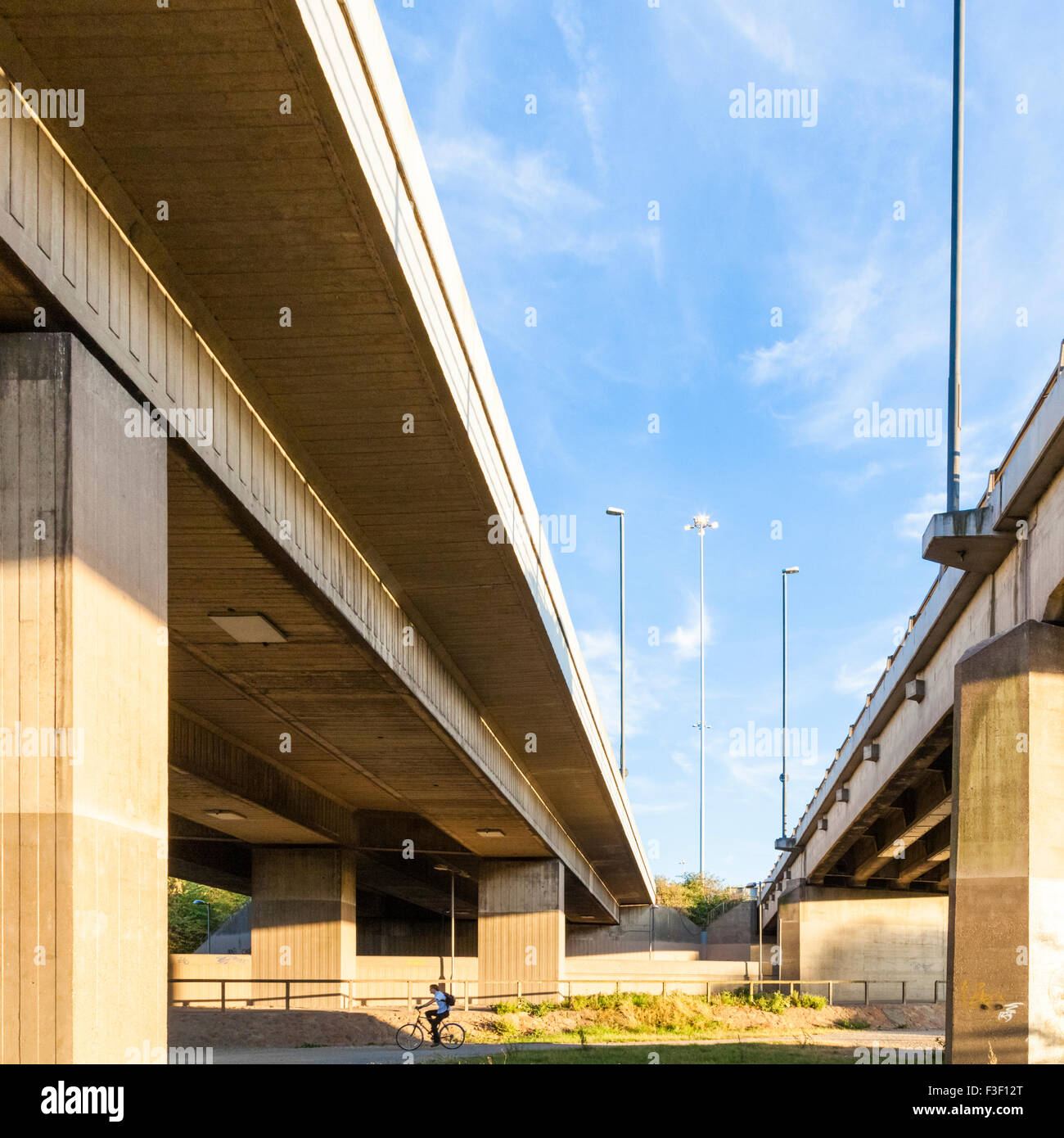 Cyclist cycling under overhead road bridge, Nottingham, England, UK ...
