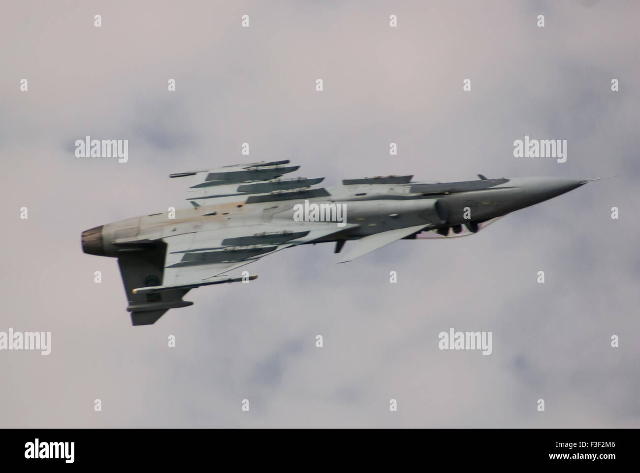 21st century fighter jet flying inverted with clouds in the background ...