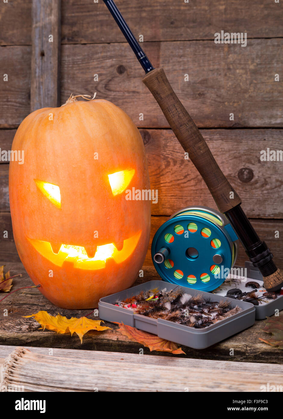 halloween pumpkin head with fly-fishing tackles on wooden boards ...