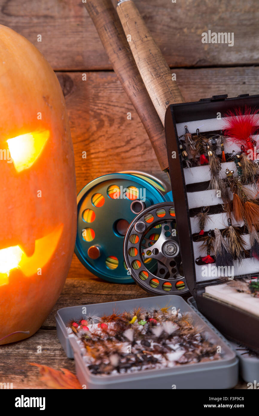 halloween pumpkin head with fly-fishing tackles on wooden boards ...