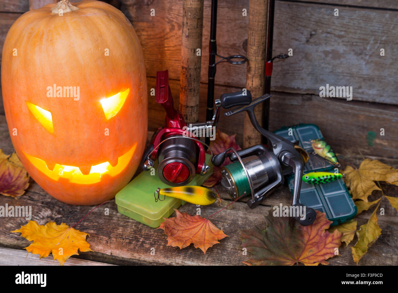 halloween pumpkin head with fishing tackles on wooden boards background ...