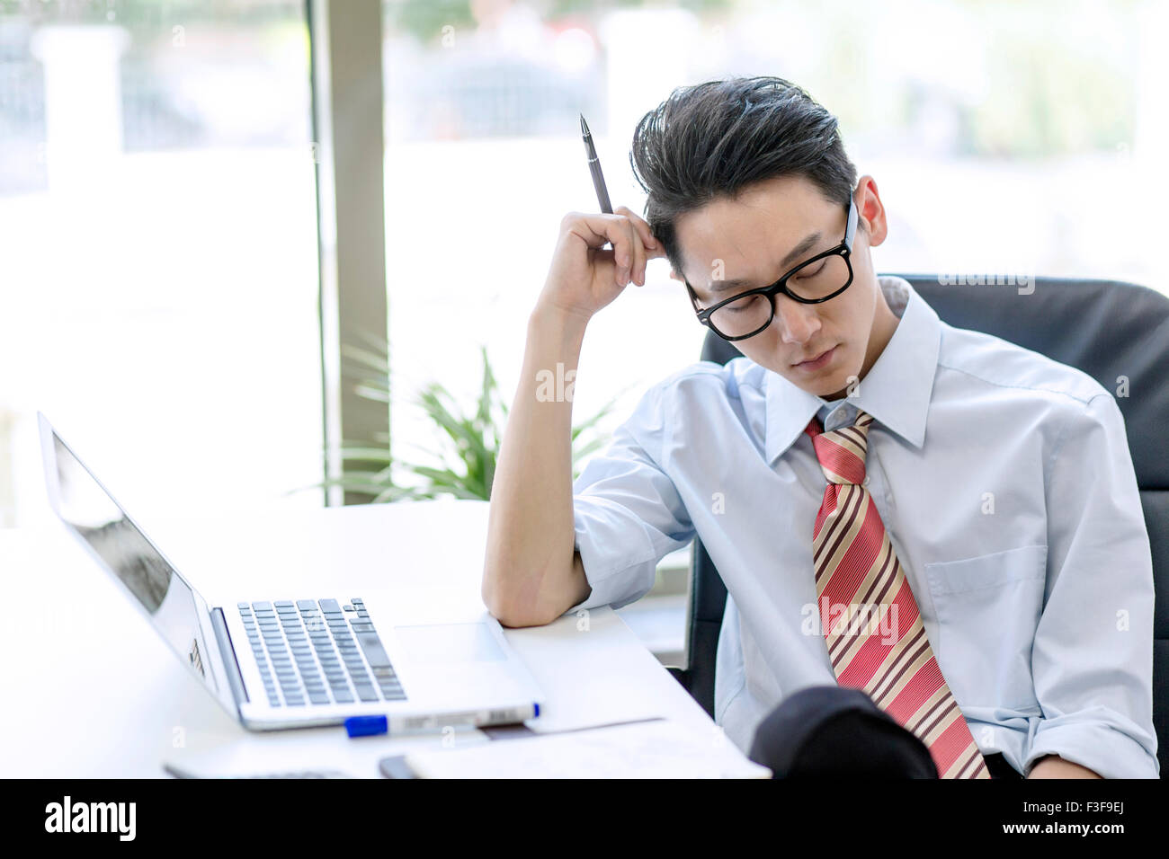 Tired businessman resting at office desk Stock Photo - Alamy