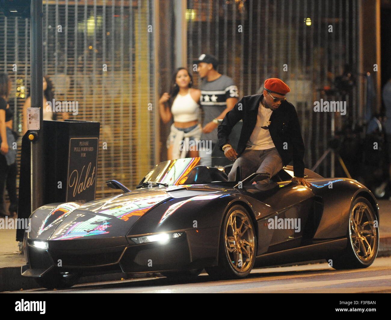 Singer Chris Brown hops out of a sports car on the set of his new music ...