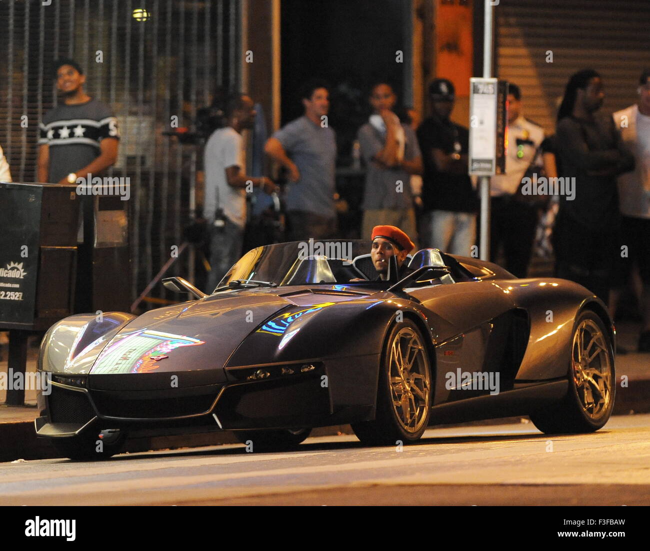 Singer Chris Brown hops out of a sports car on the set of his new music ...