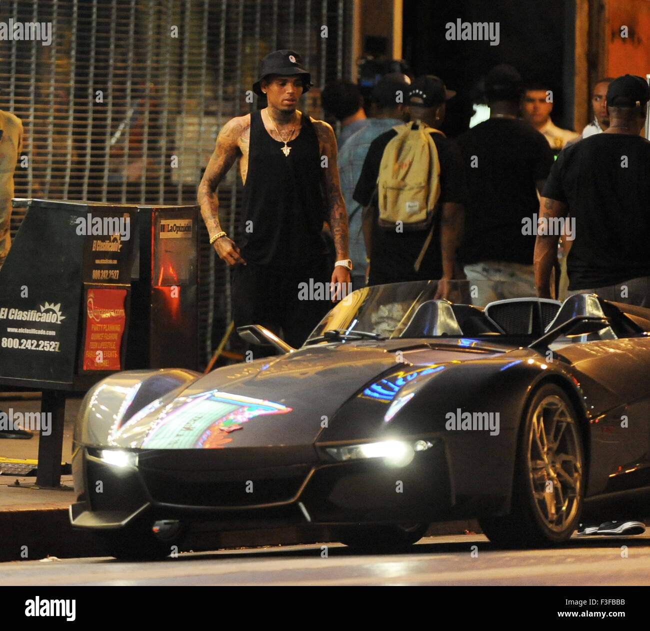 Singer Chris Brown hops out of a sports car on the set of his new music ...
