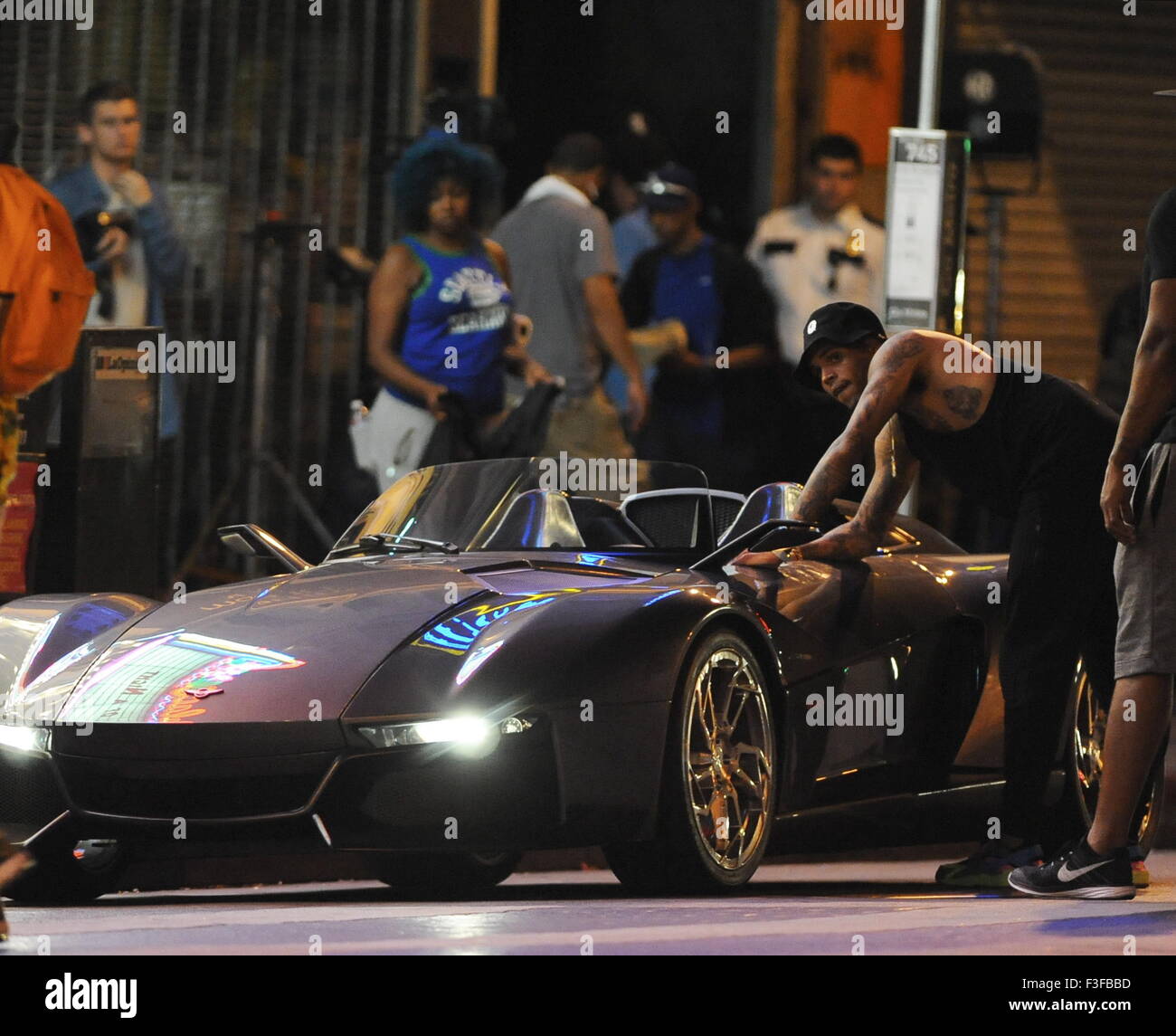 Singer Chris Brown hops out of a sports car on the set of his new music ...