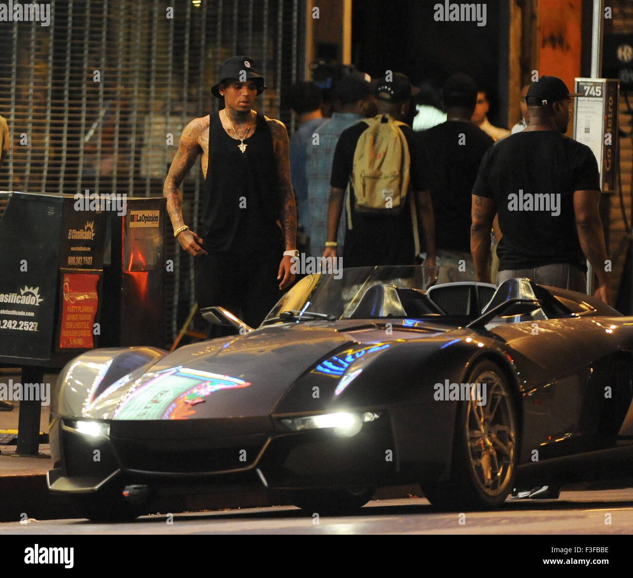Singer Chris Brown hops out of a sports car on the set of his new music ...