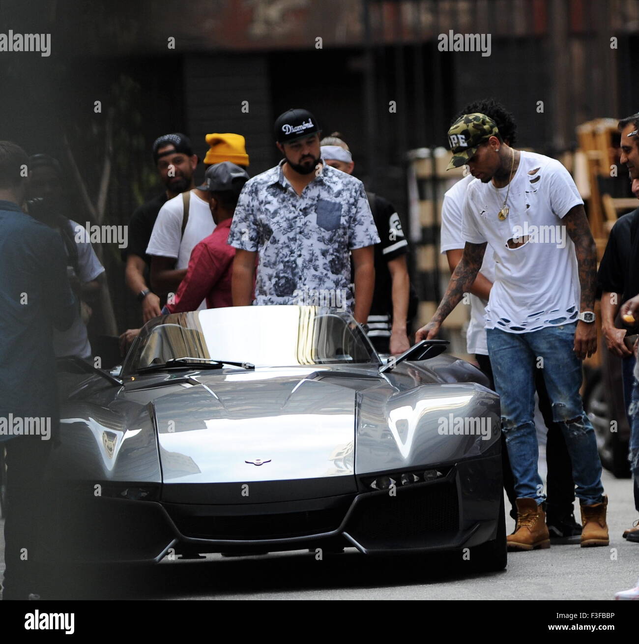Singer Chris Brown hops out of a sports car on the set of his new music ...