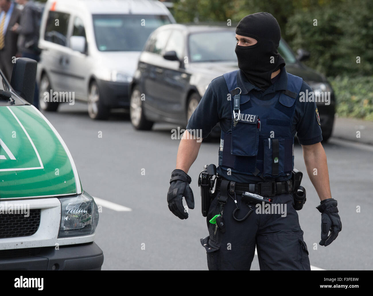 A masked police officer is in action searching objects and people at ...