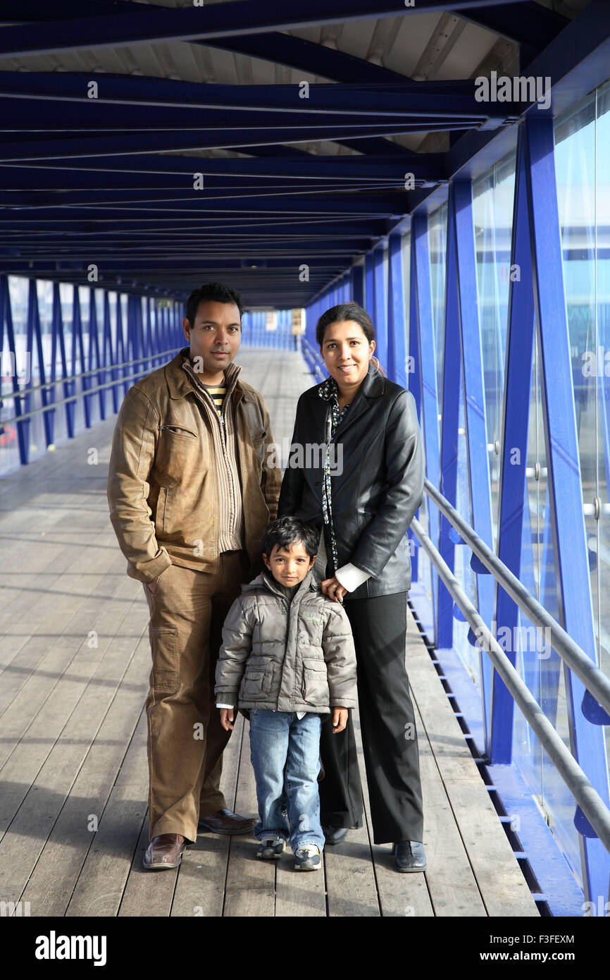 Parent with four years old son standing and posing on pedestrian bridge ...