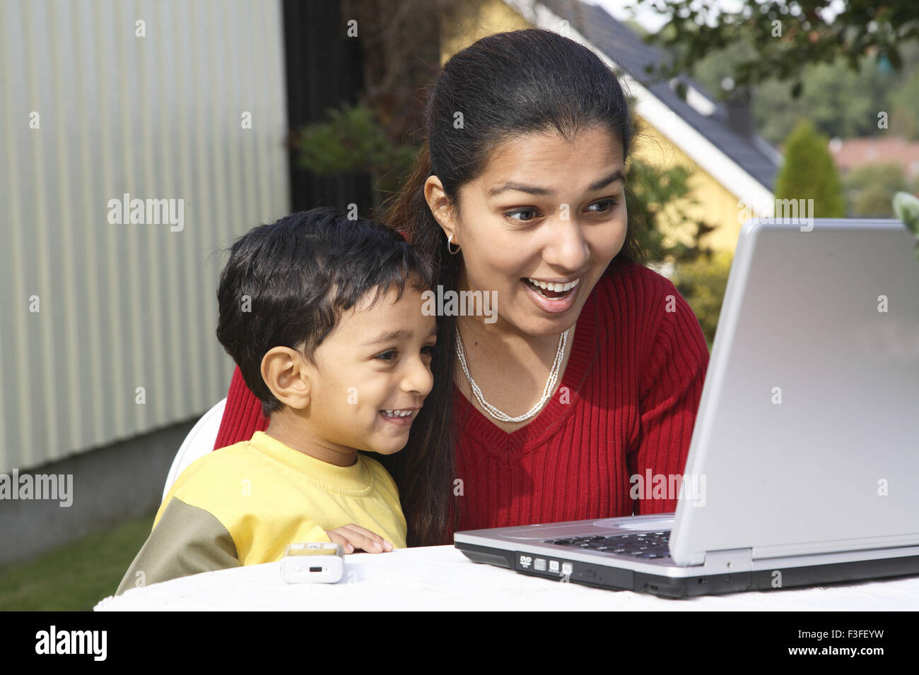 Mother and boy looking excitingly at screen of laptop MR#468 Stock ...