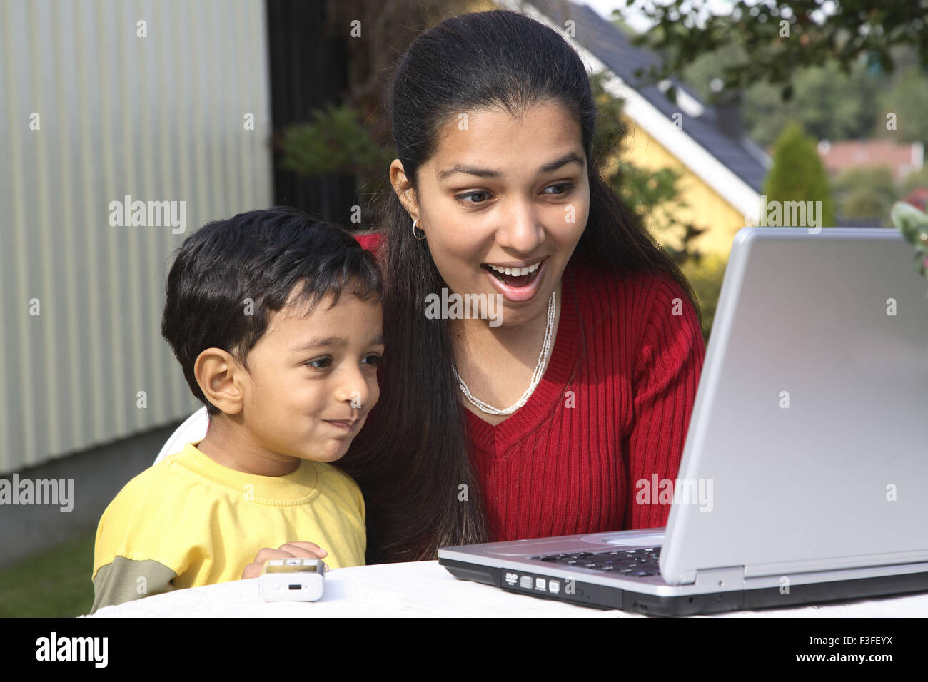 Mother and boy looking excitingly at screen of laptop MR#468 Stock ...