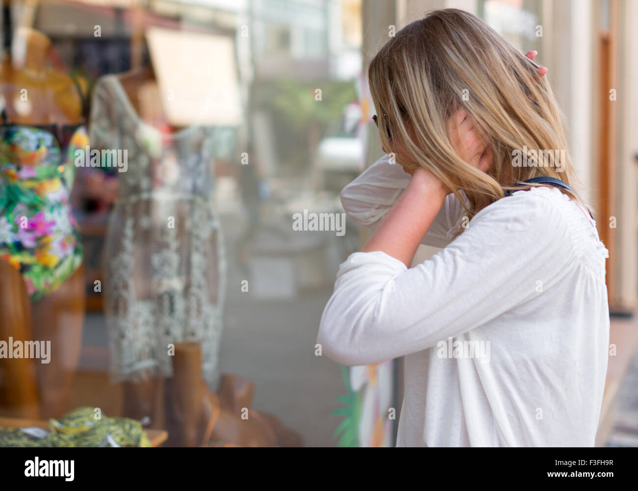 Woman looking at display window in fashion store Stock Photo - Alamy