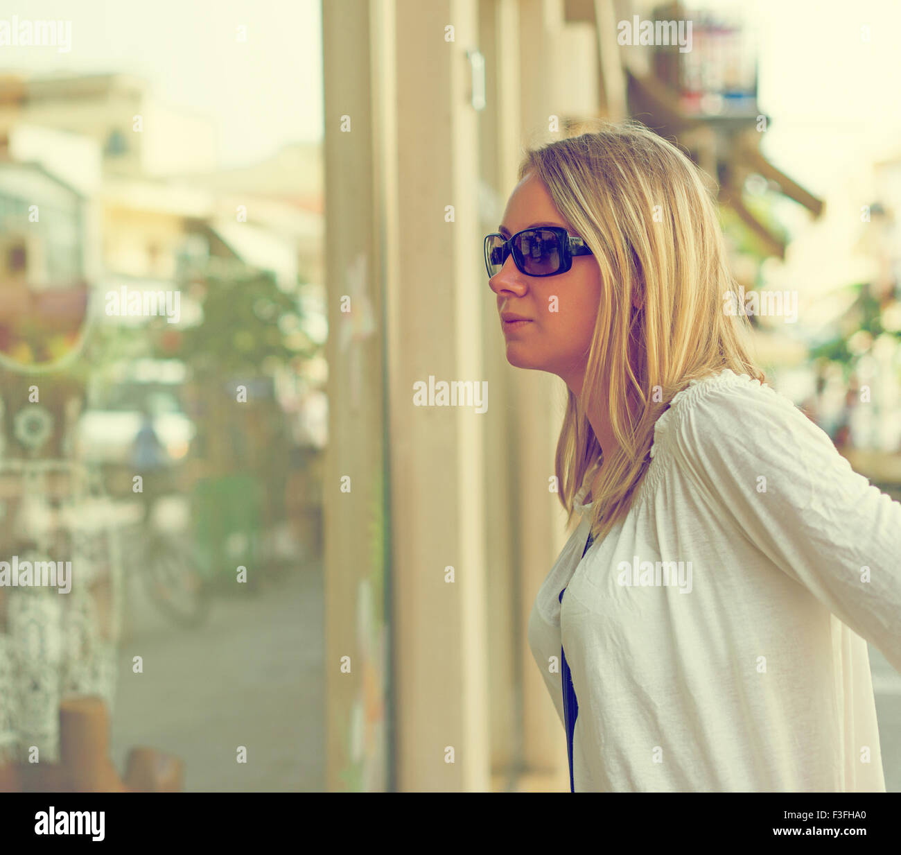 Woman looking at display window in fashion store Stock Photo - Alamy