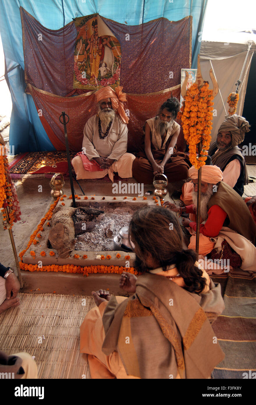 Naga sadhus from the Juna Akadha sits with his Trishul at their camp ...