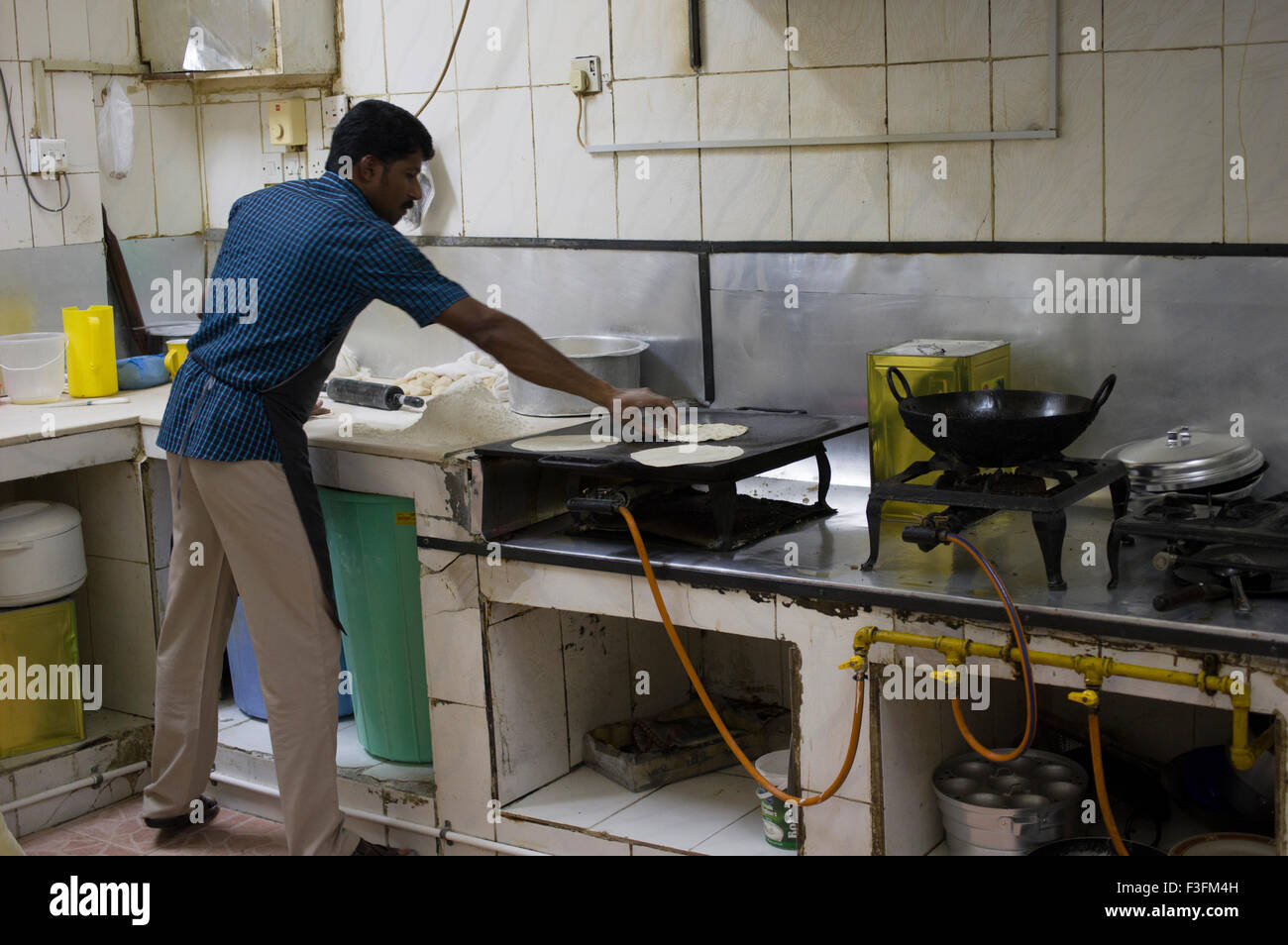 A chef cooking chapatis in a small restaurant in Muscat in the ...
