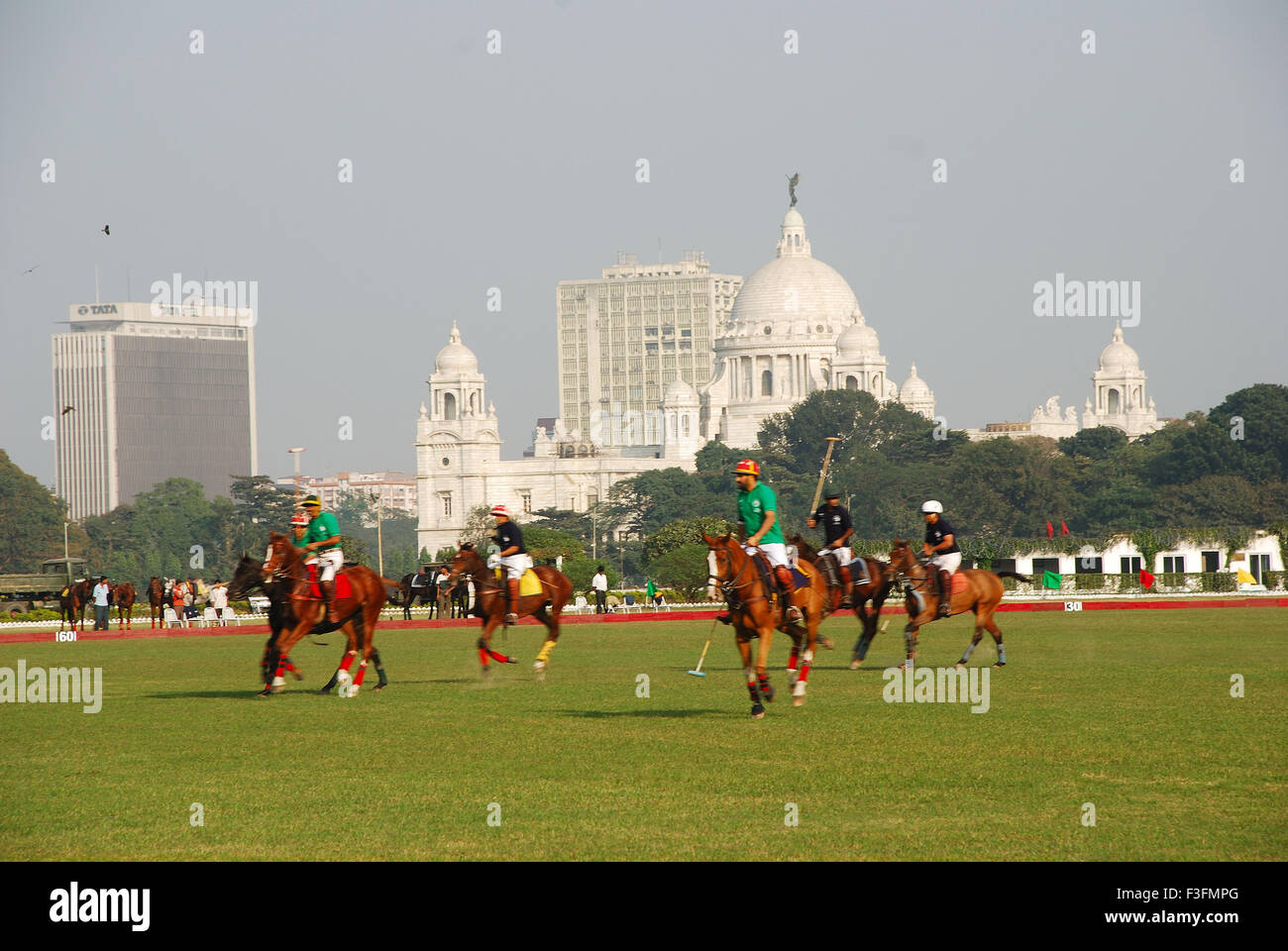 Players playing polo match on ground and Victoria memorial in ...