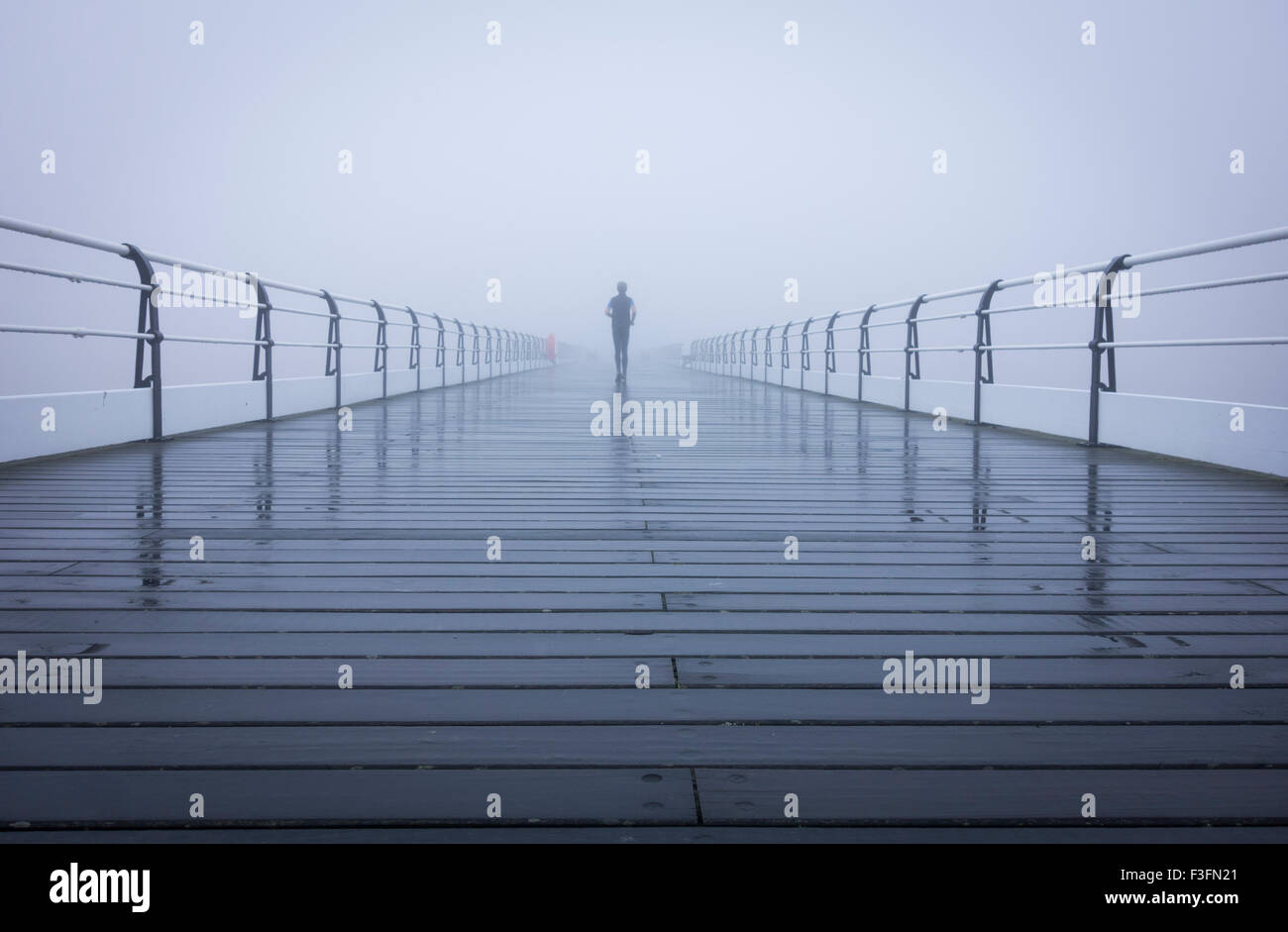 Mature man jogging on Saltburn pier in the rain. Saltburn by the sea ...