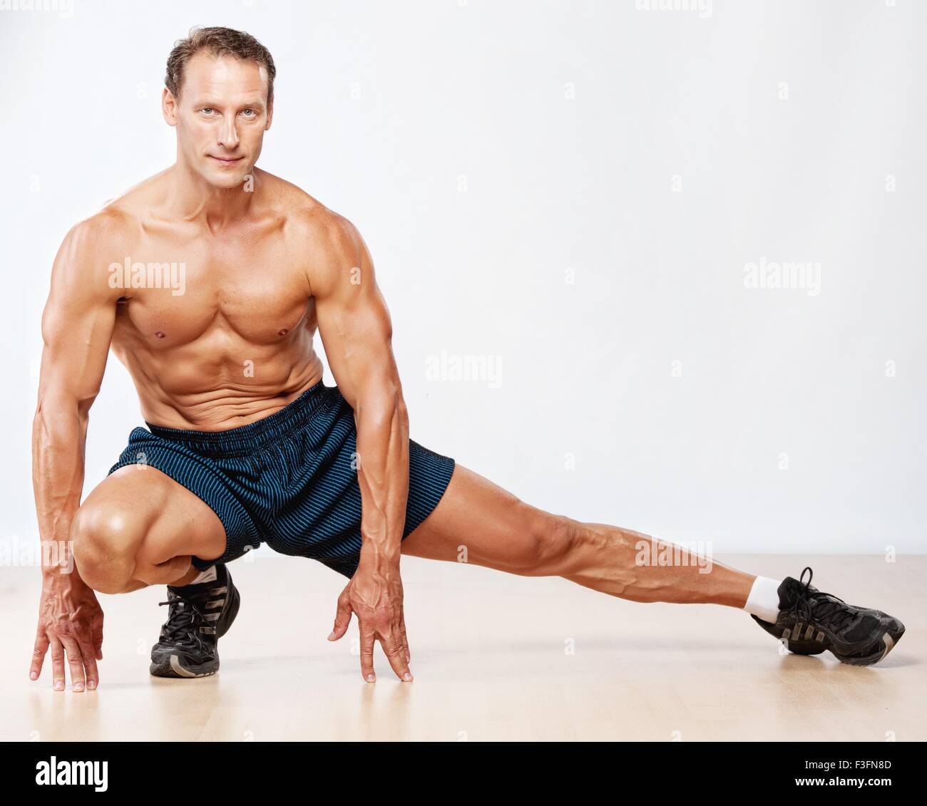 Handsome muscular man doing stretching exercise Stock Photo - Alamy