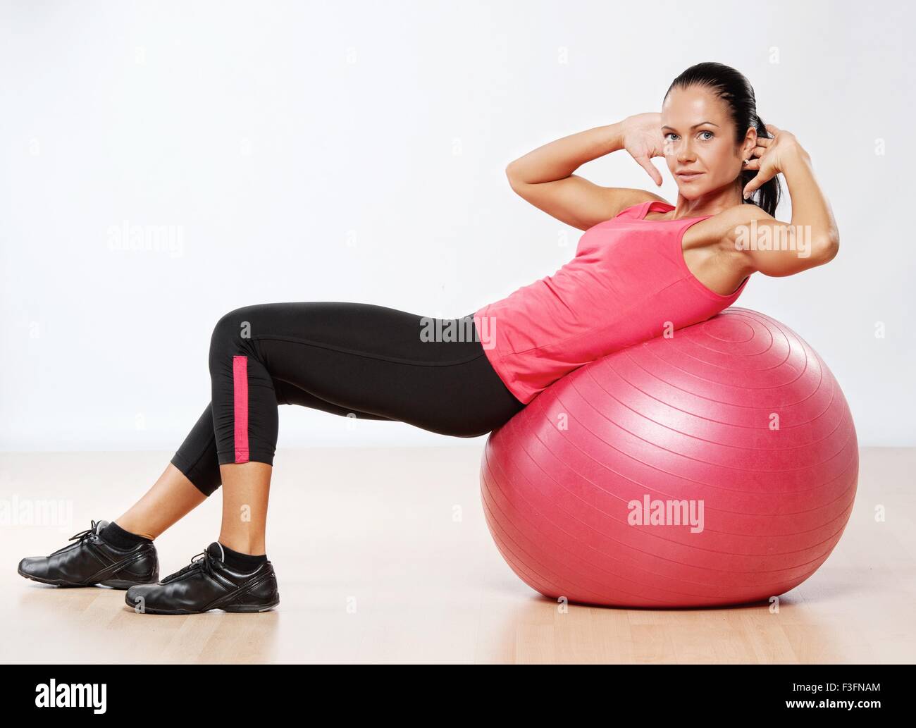 Beautiful athlete woman with a fitness ball Stock Photo - Alamy
