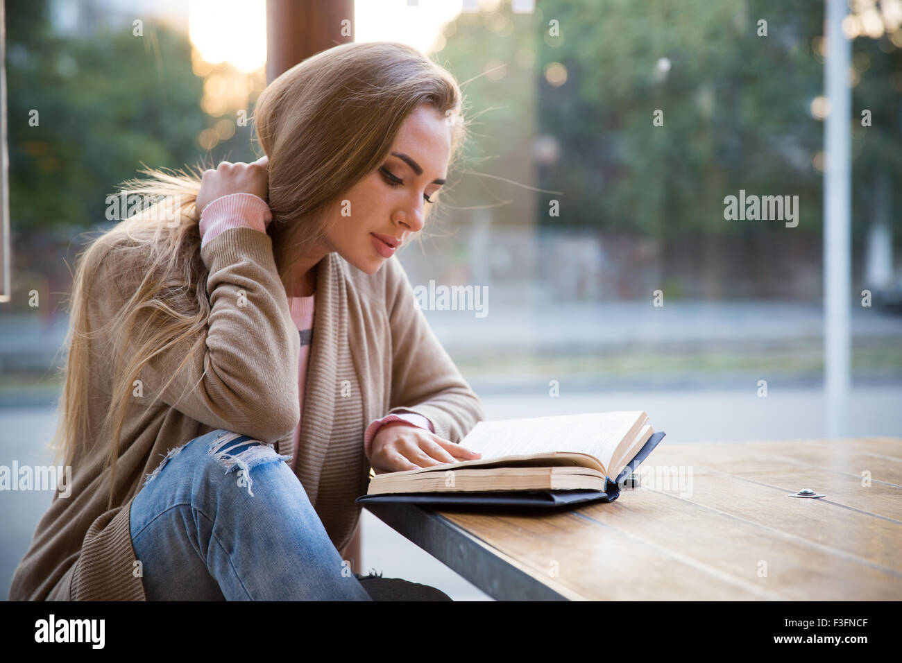 Portrait of a beautiful girl reading book in cafe Stock Photo - Alamy