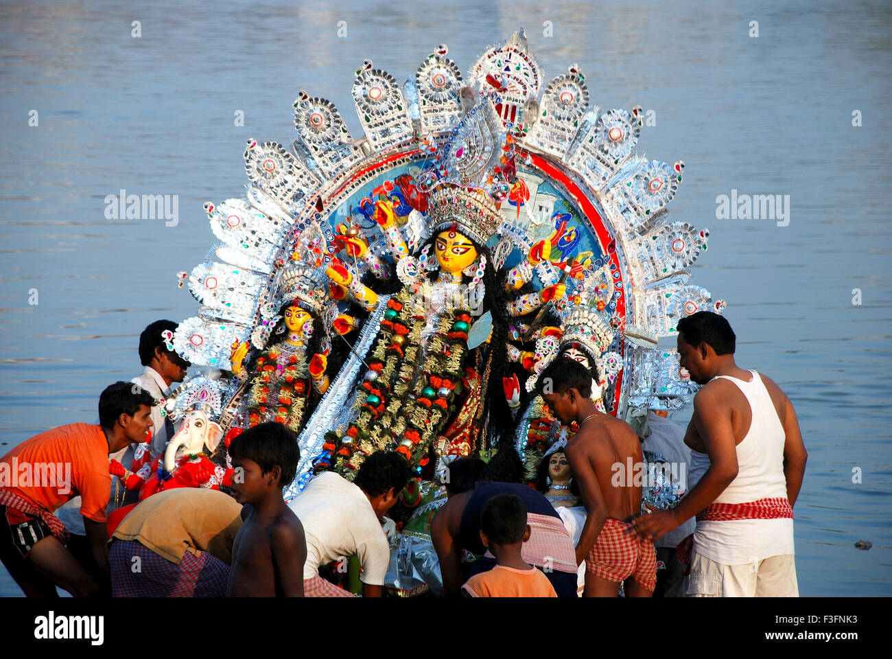 Devotees immersing Durga model in river Stock Photo - Alamy
