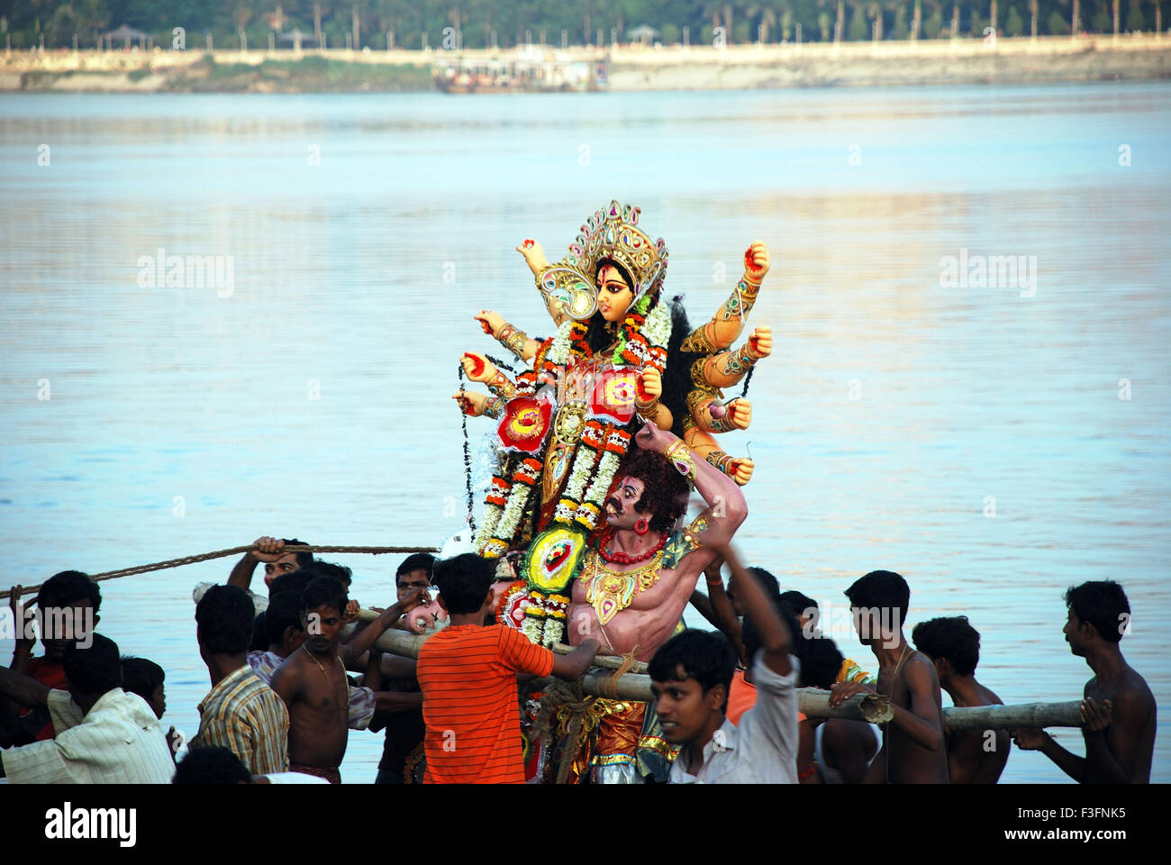 Devotees immersing Durga model in river Stock Photo - Alamy
