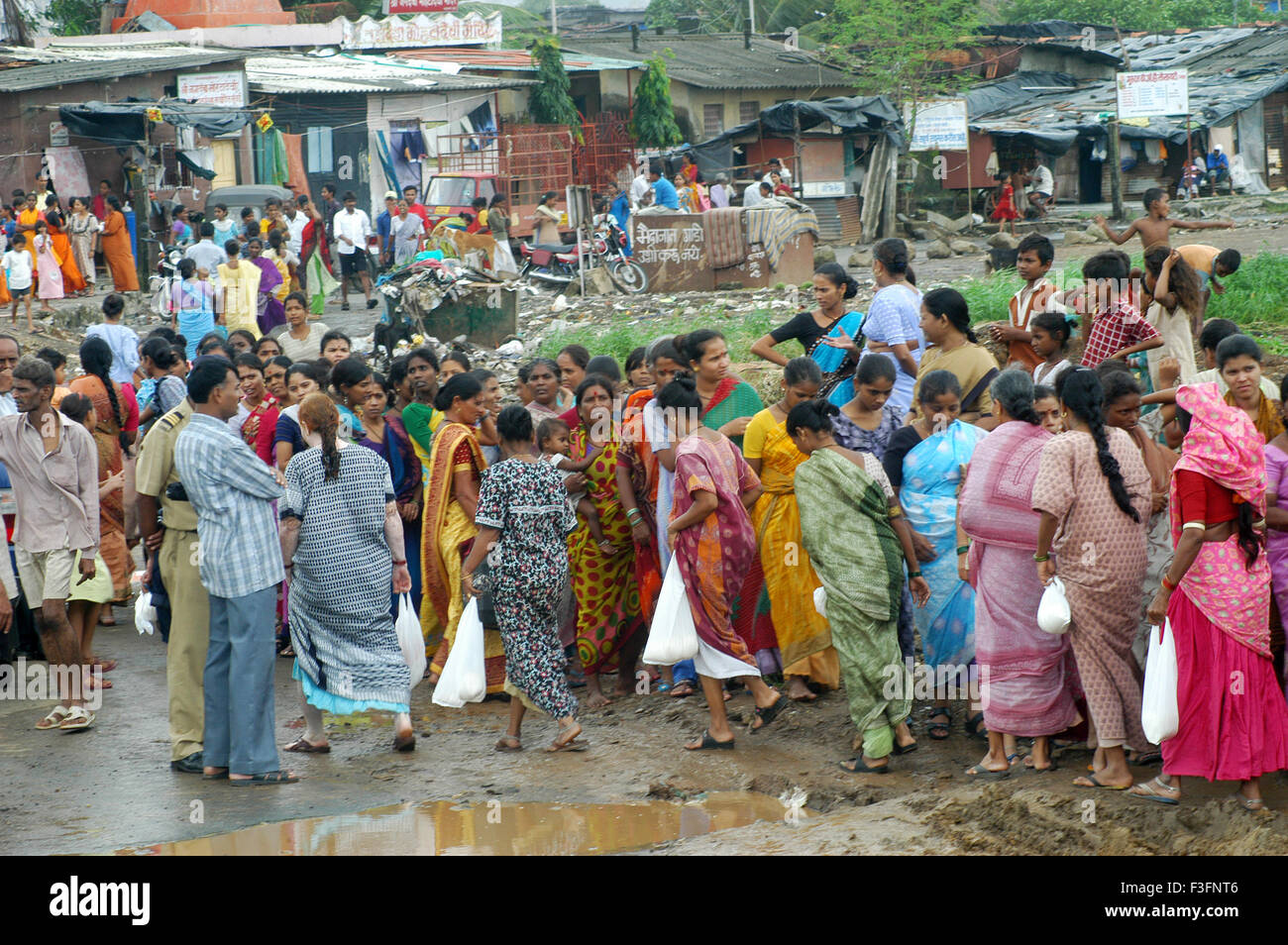 Slum dwellers stand in queue to collect relief materials distributed by ...