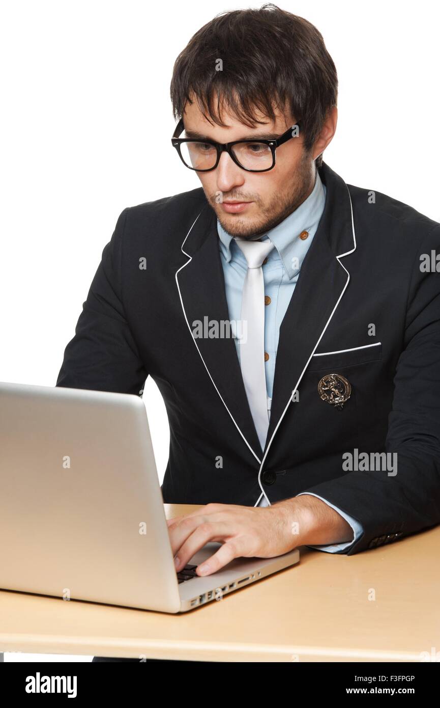 Handsome young man with a laptop behind desk Stock Photo - Alamy
