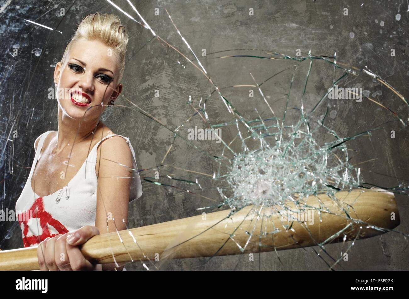 Punk girl breaking glass with a bat Stock Photo - Alamy