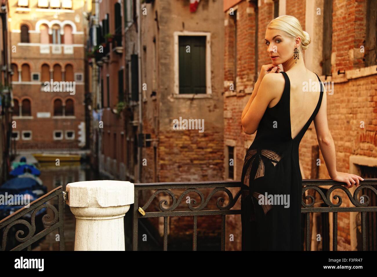 Beautiful woman in black dress on a bridge Stock Photo - Alamy
