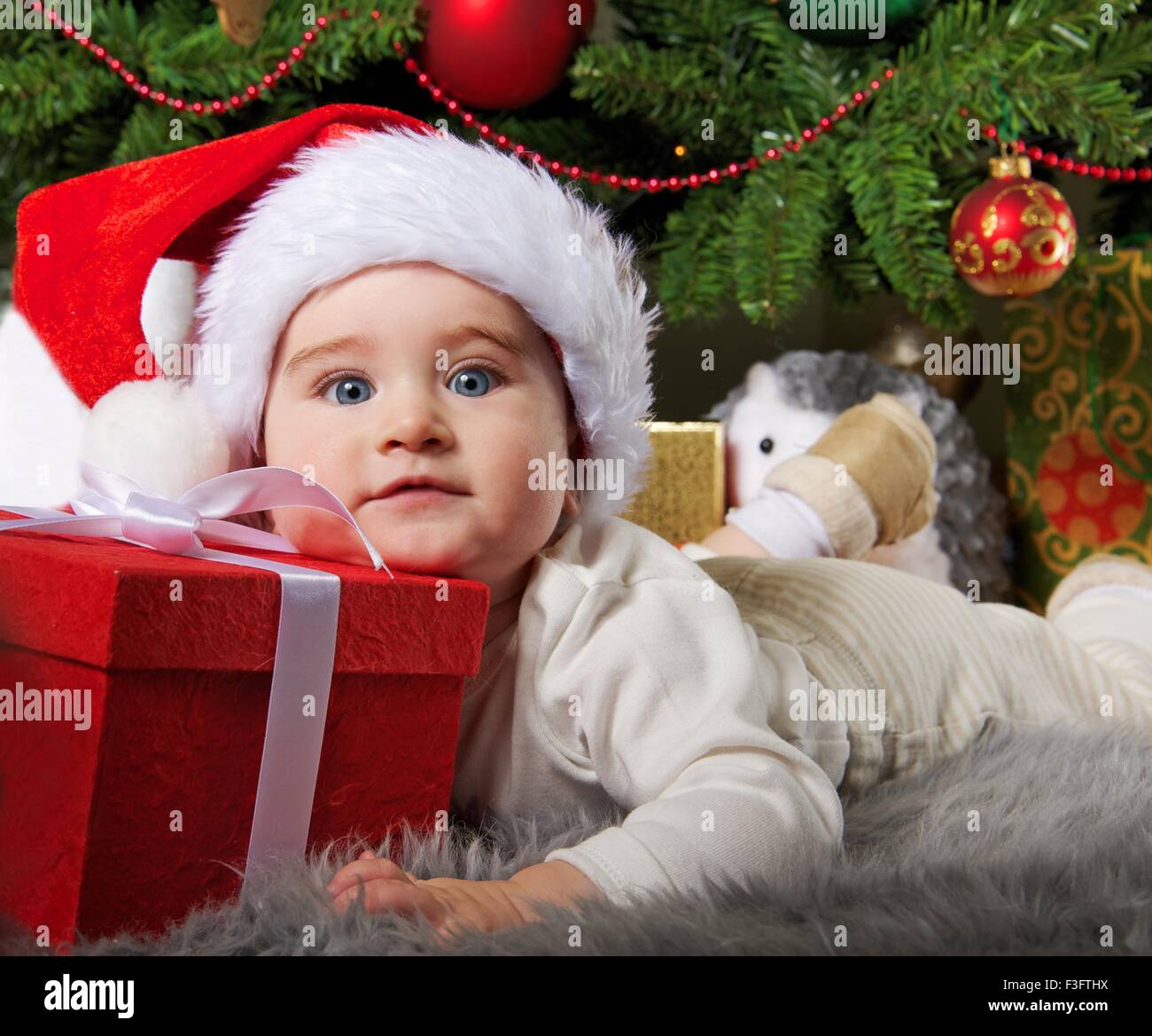 Santa baby playing with gift box Stock Photo - Alamy