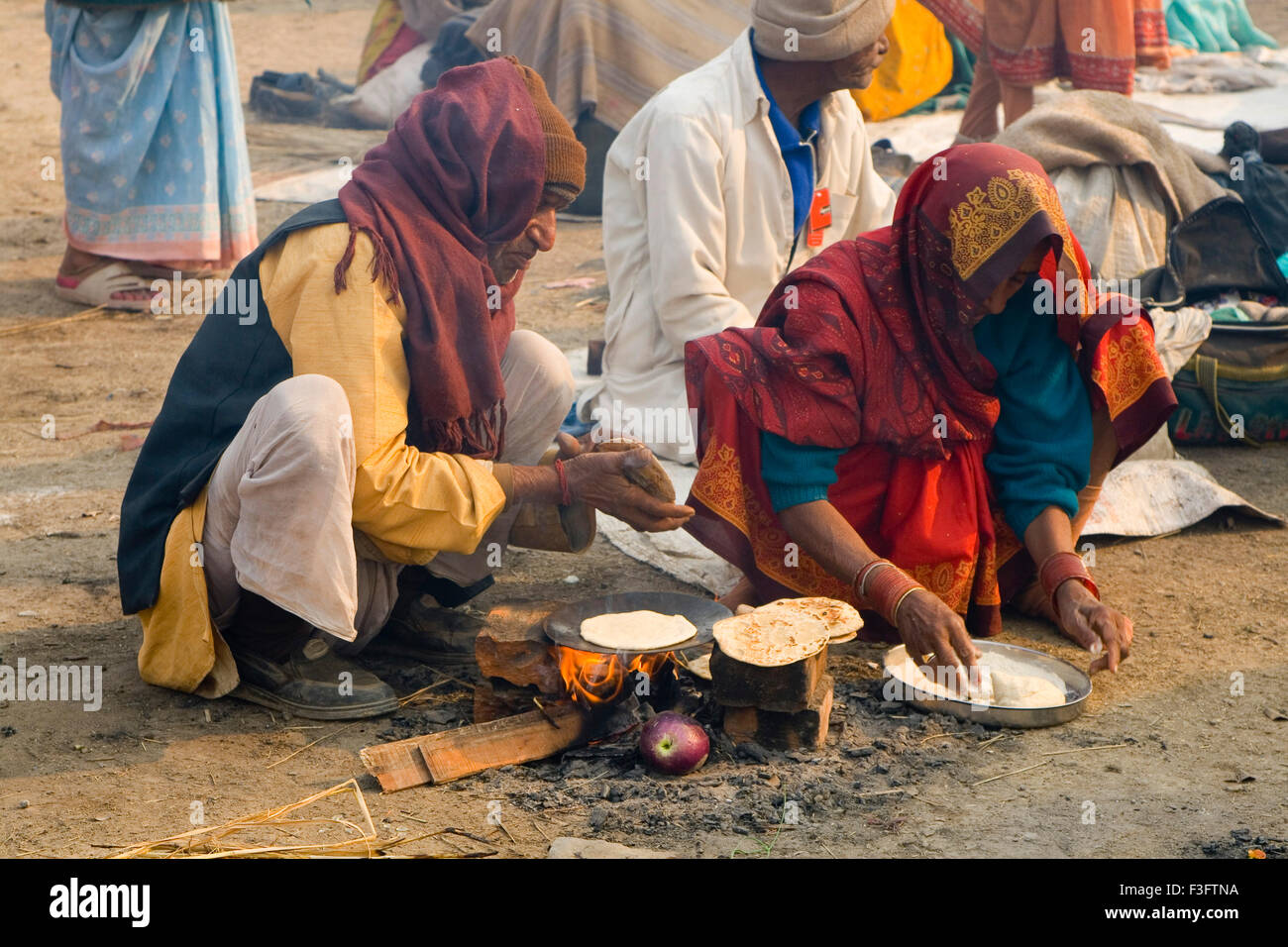 Couple cooking food in Kumbh mela ; Allahabad ; Uttar Pradesh ; India ...