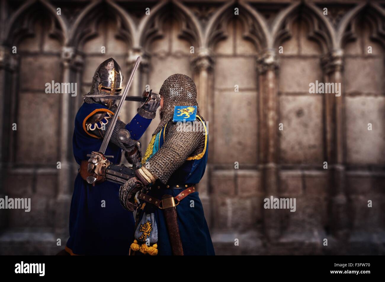 Two knights fighting against medieval cathedral wall Stock Photo - Alamy