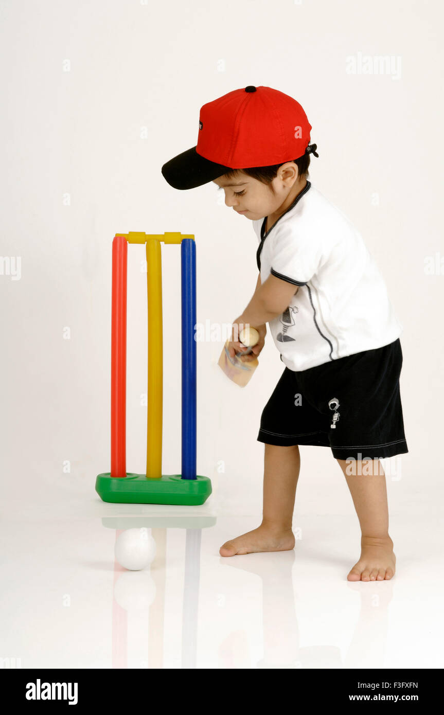 Indian Boy swinging the bat to hit the ball playing cricket ; MR Stock ...