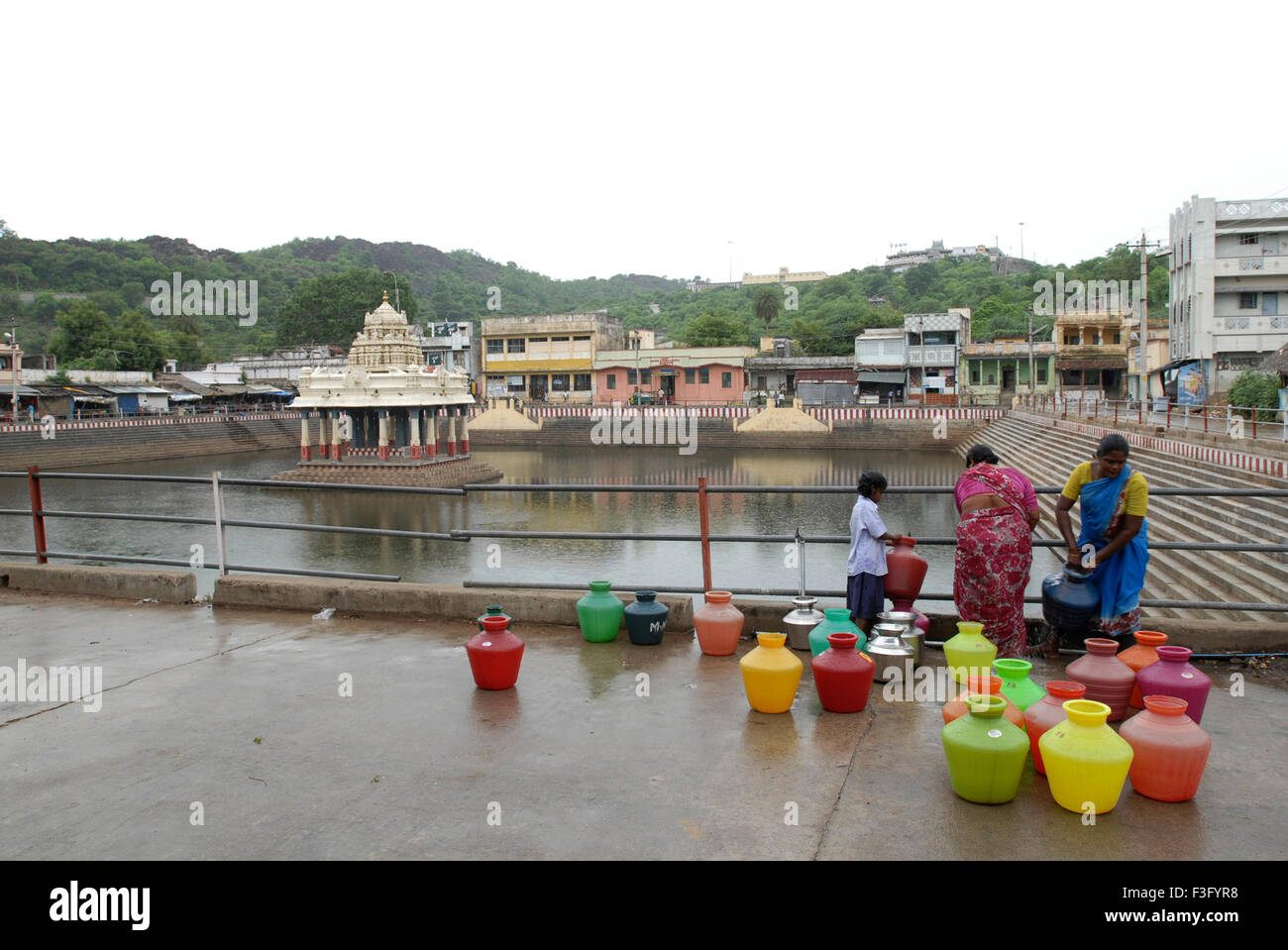 Women collecting drinking water from municipal tap near Saravana Poigai ...