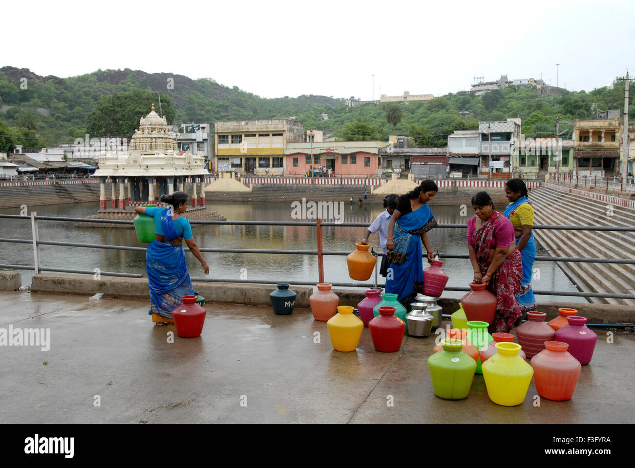 Women collecting drinking water from municipal tap near Saravana Poigai ...