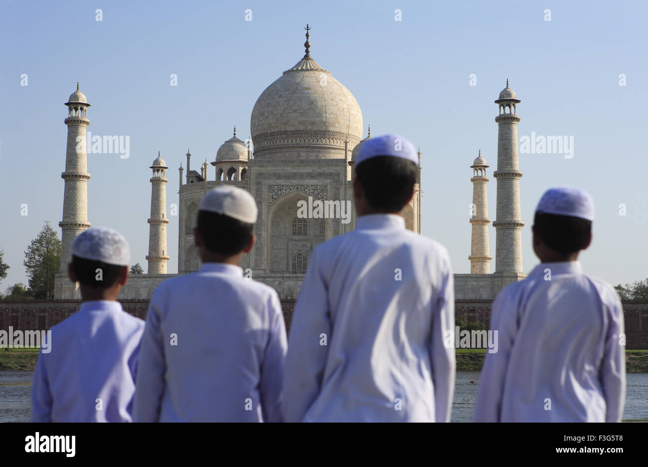 Young muslim boys performing religious prayer Namaz in front of Taj ...