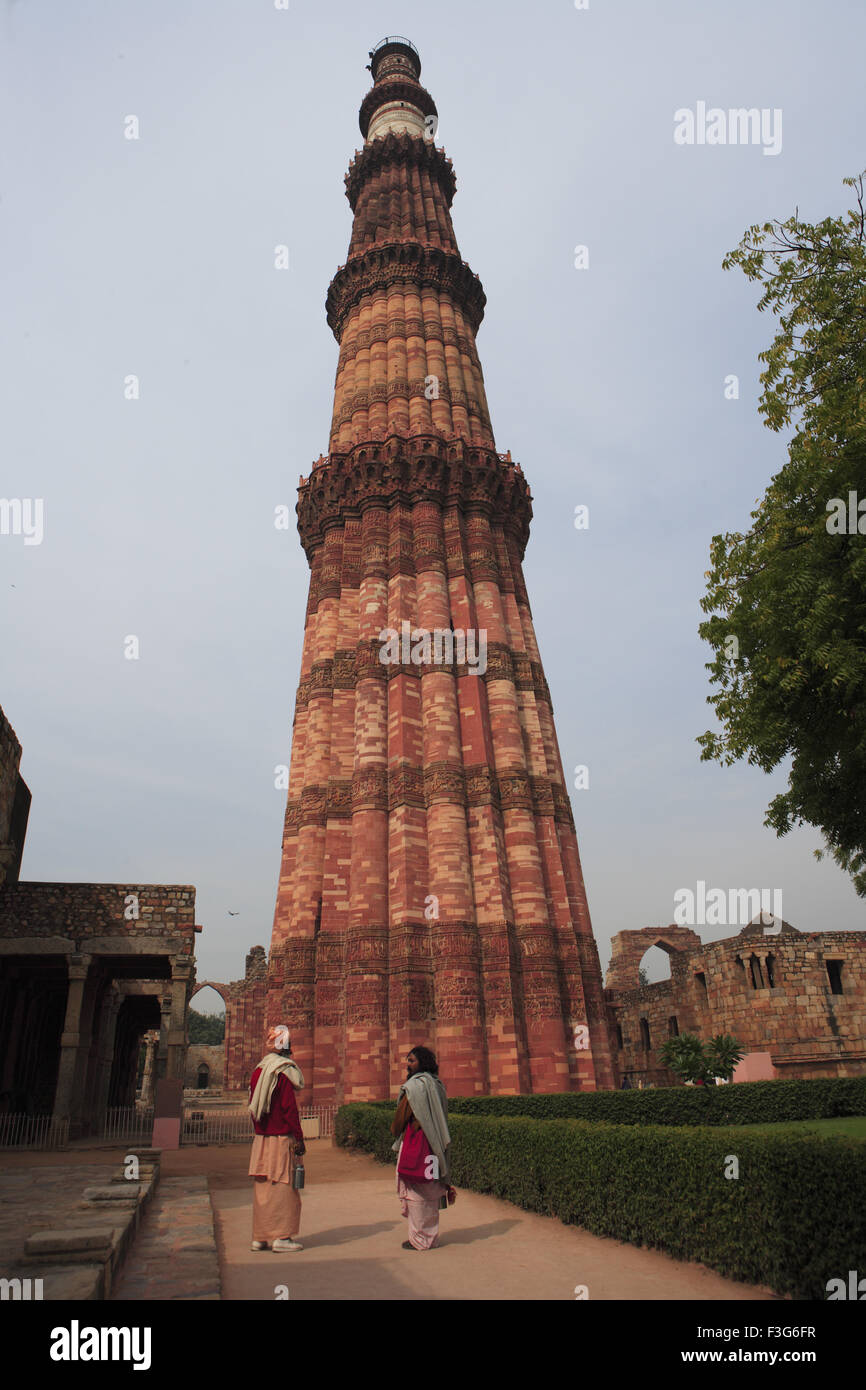 Indian sadhu watching Qutb Minar built in 1311 red sandstone tower ...
