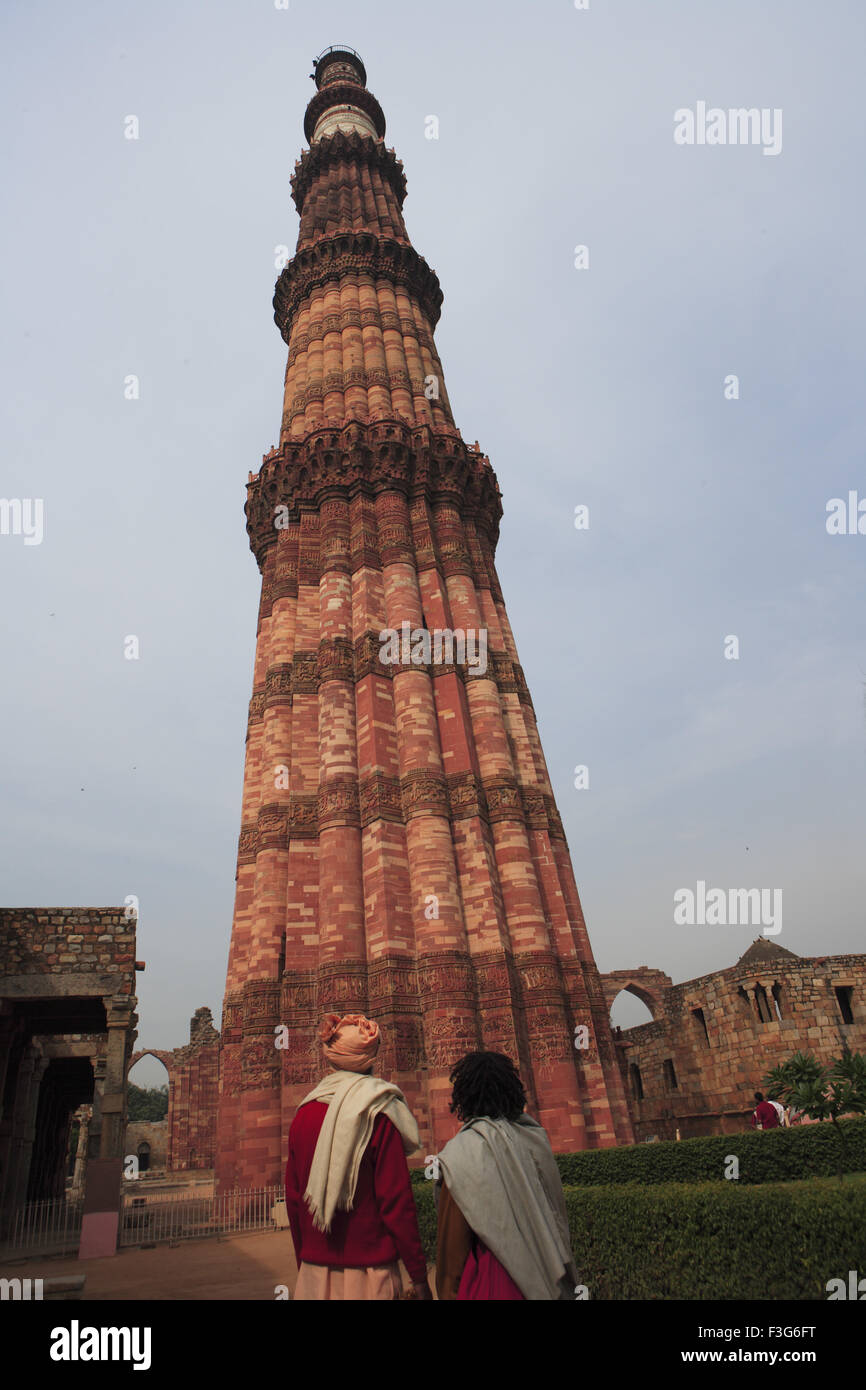 Indian sadhu watching Qutb Minar built in 1311 red sandstone tower ...