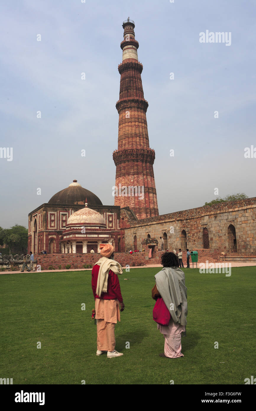 Indian sadhu watching Qutb Minar built in 1311 red sandstone tower ...