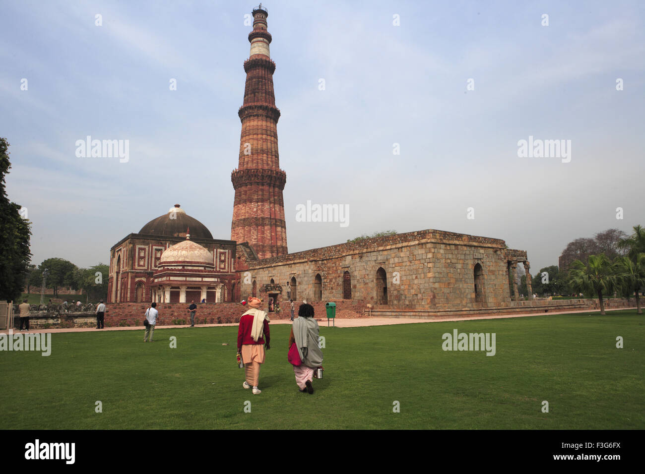 Indian sadhus watching Qutb Minar; built in 1311 the red sandstone ...