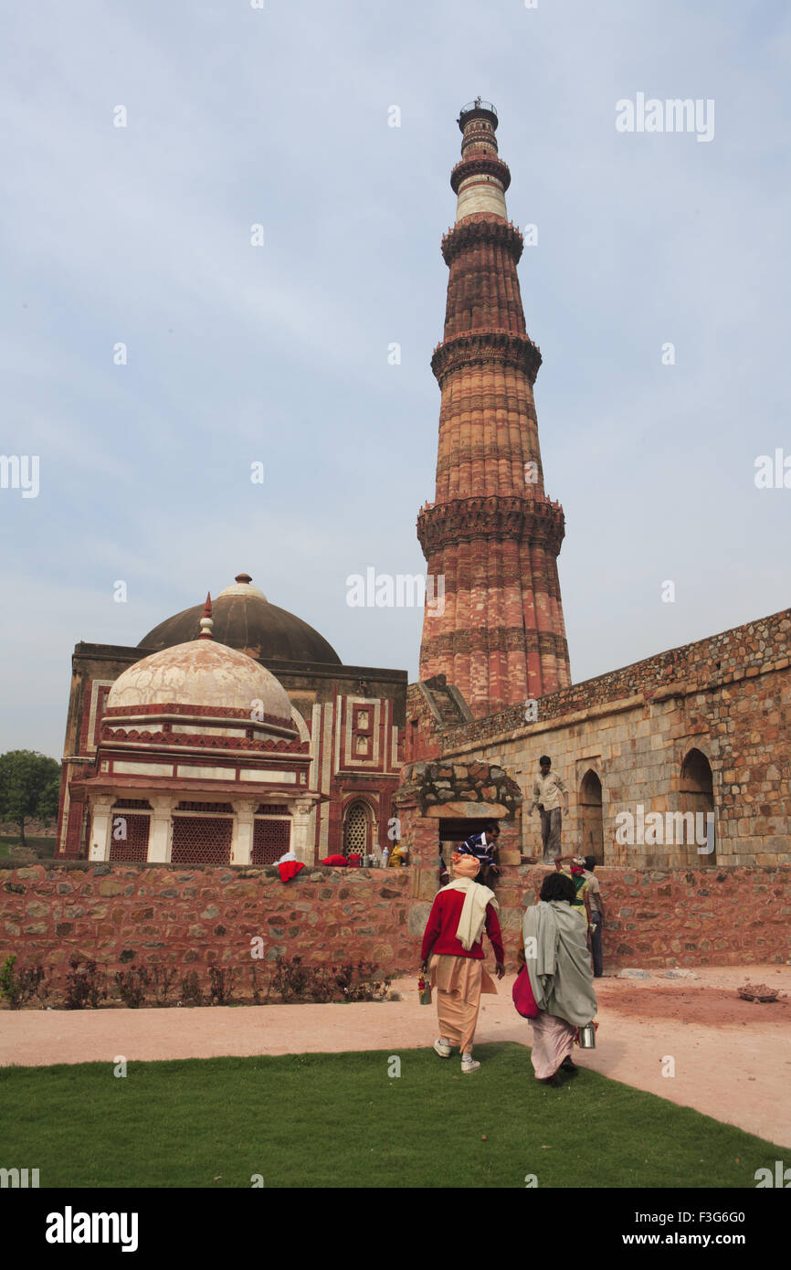 Indian sadhu watching Qutb Minar built in 1311 red sandstone tower ...